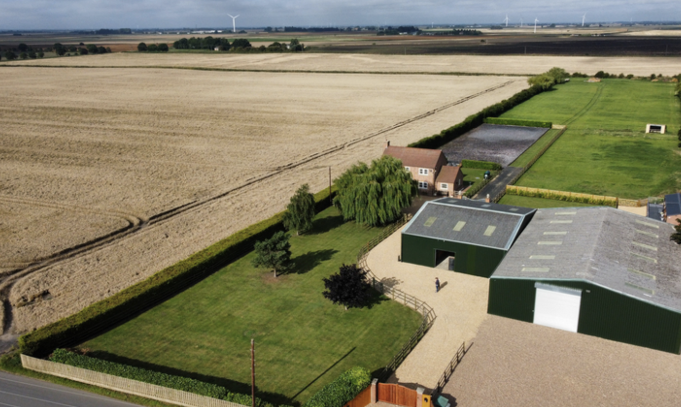 An immaculate equestrian set-up with indoor and outdoor arenas, stables ...